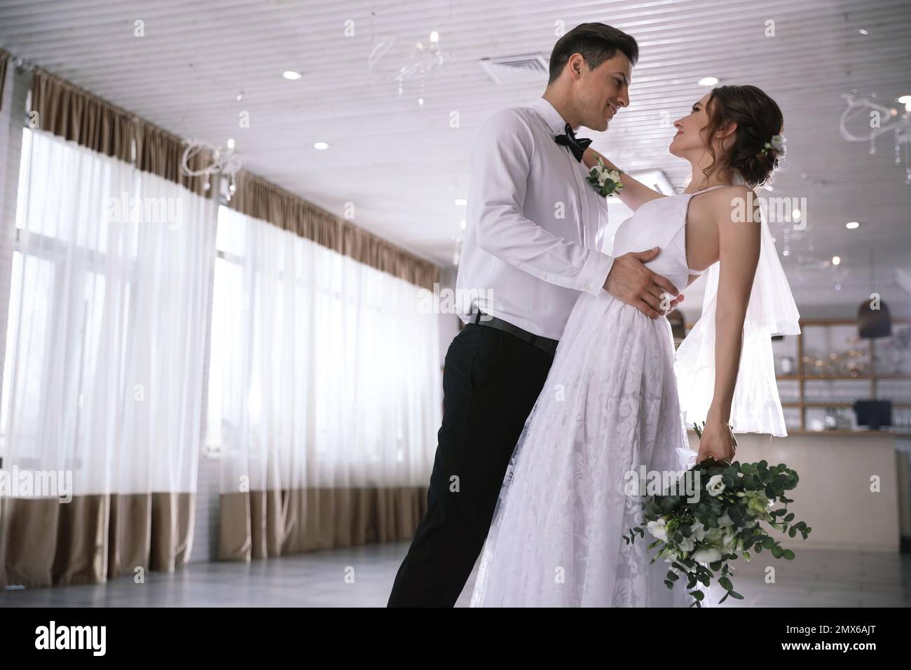 Happy newlywed couple dancing together in festive hall Stock Photo - Alamy
