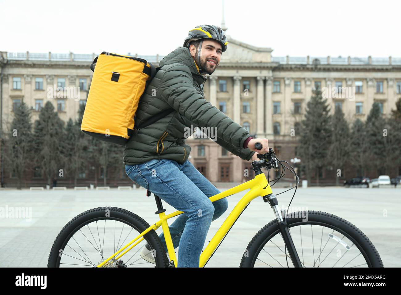 Courier with thermo bag riding bicycle outdoors. Food delivery service ...