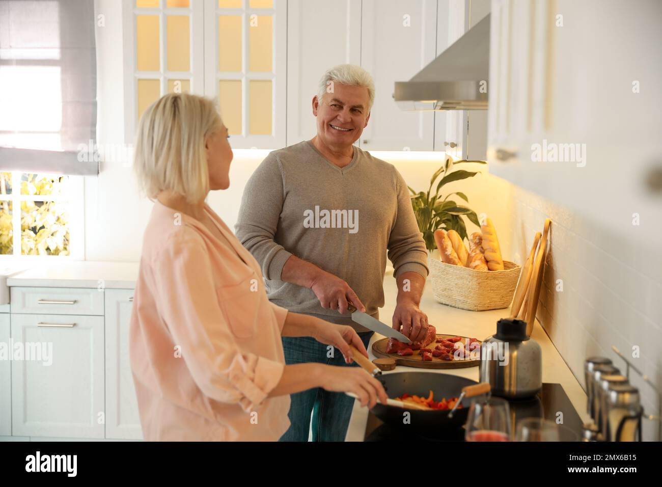Mature couple cooking food together in kitchen Stock Photo - Alamy