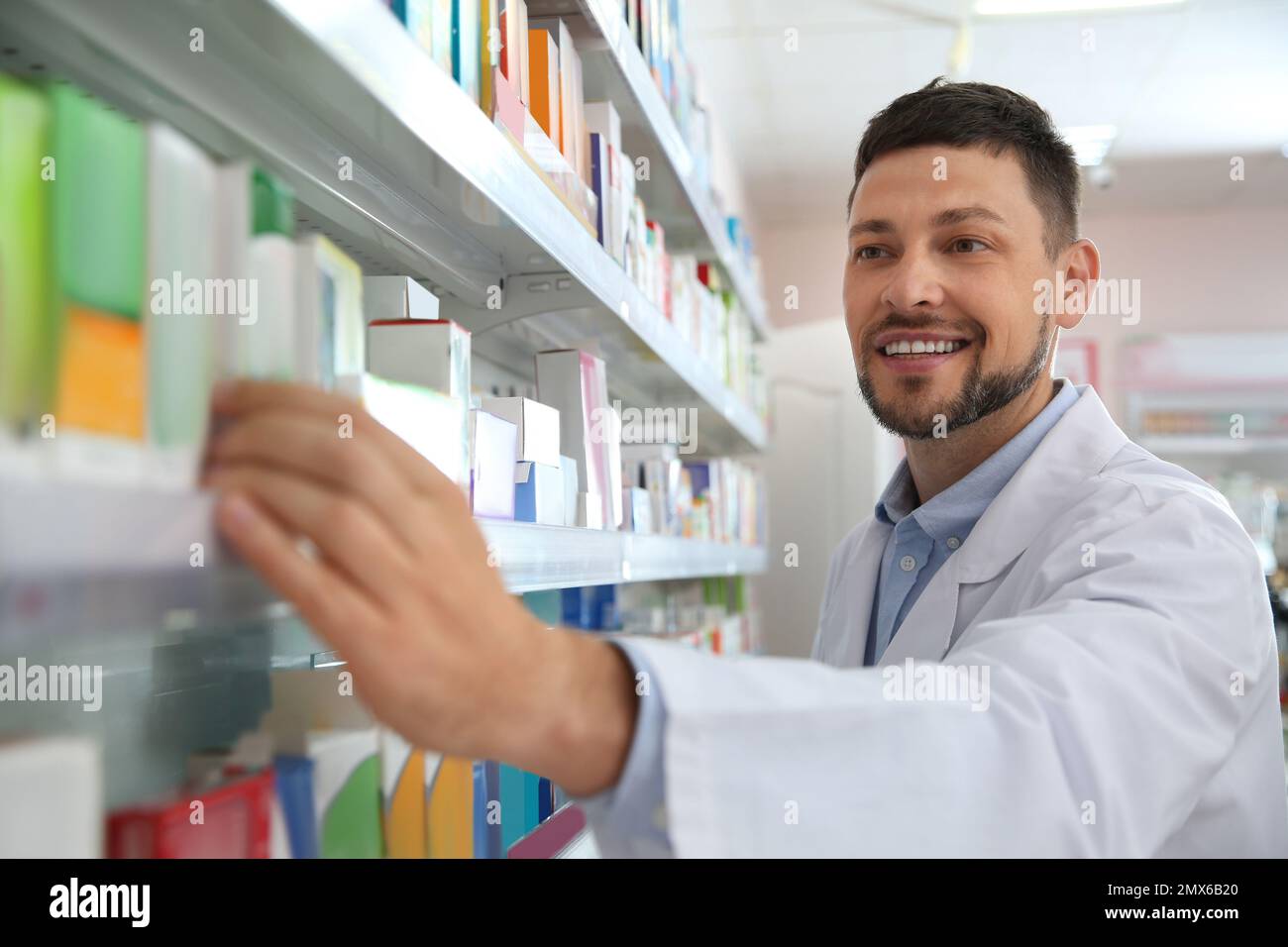 Professional pharmacist near shelves with medicines in drugstore Stock ...