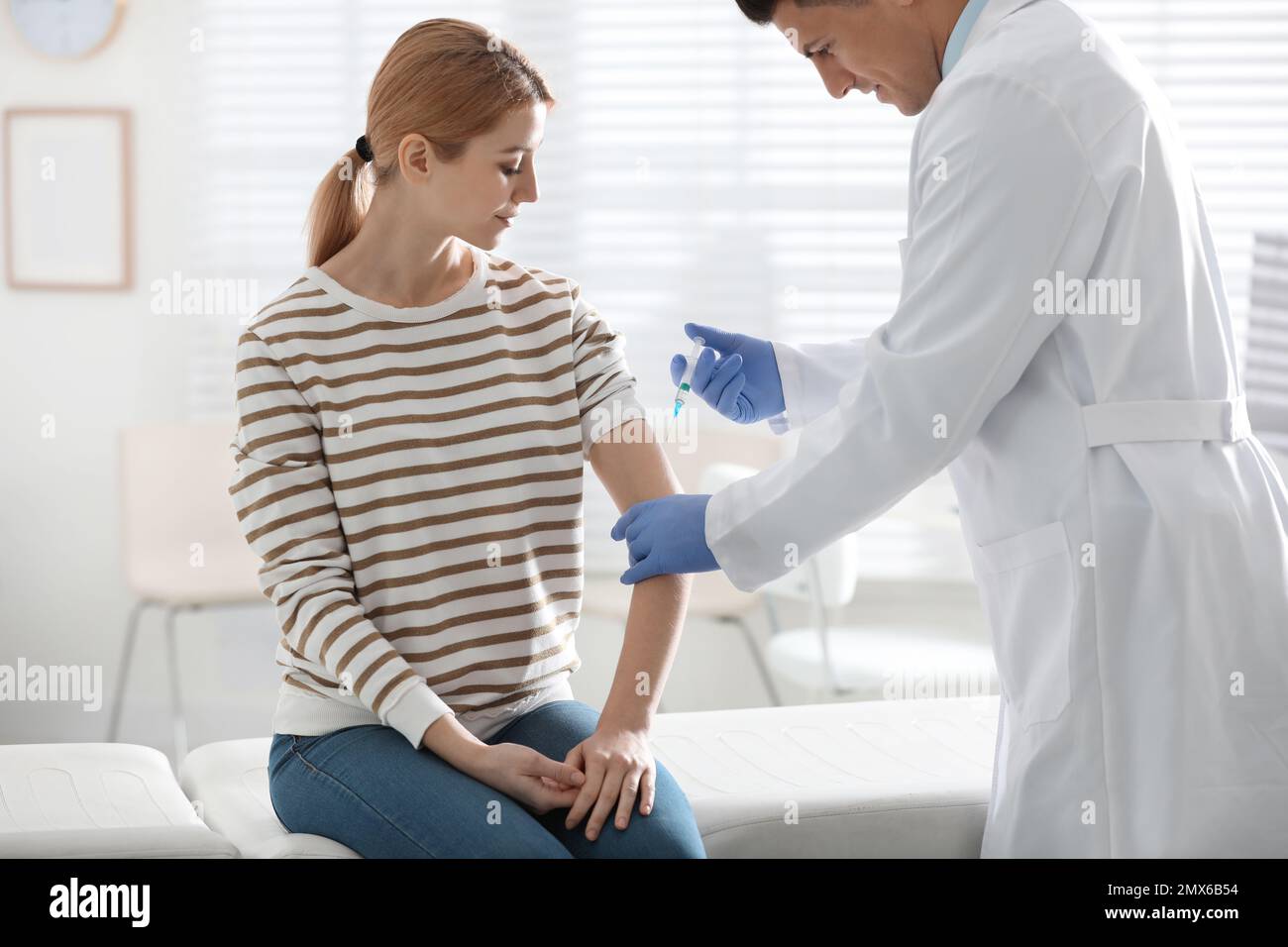 Doctor giving injection to patient in hospital. Vaccination concept ...