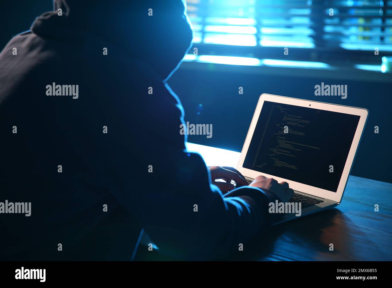Hacker with laptop in dark room. Cyber crime Stock Photo - Alamy