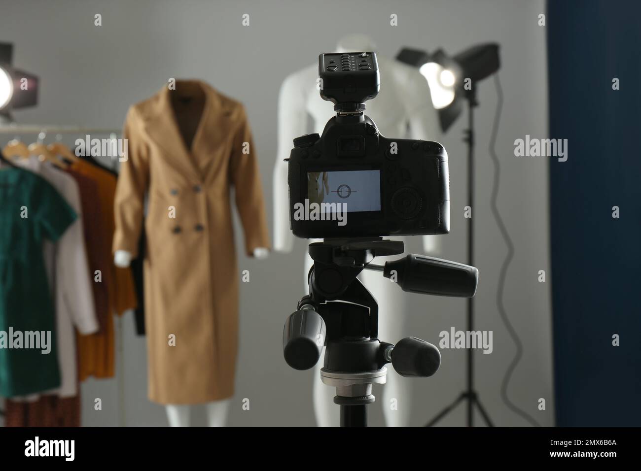 Ghost mannequins, clothes and professional lighting equipment in modern ...