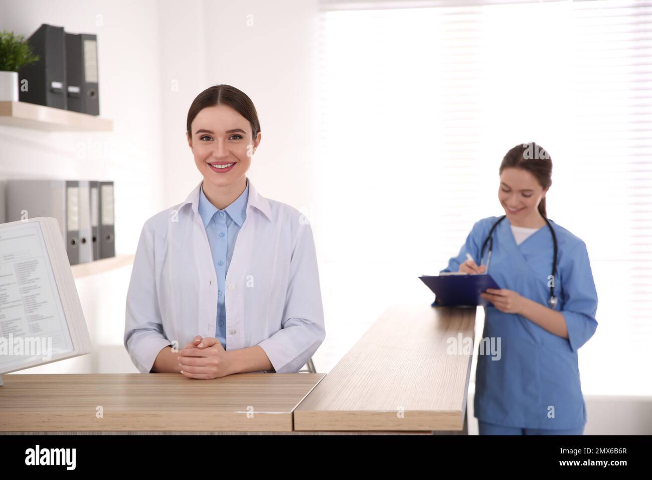 Portrait of female doctor at counter in modern clinic Stock Photo - Alamy
