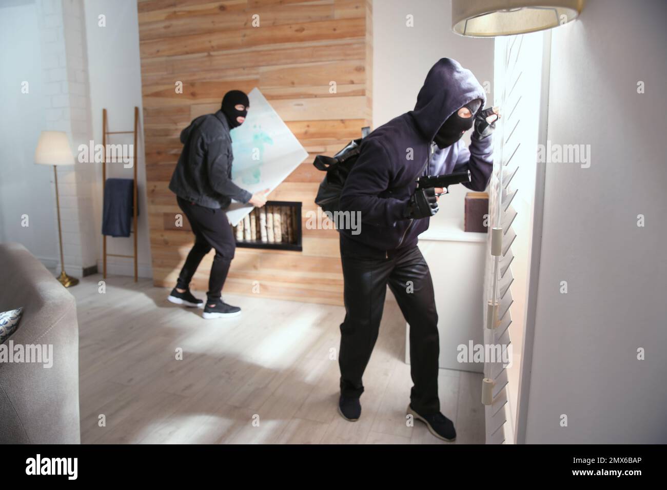 Dangerous masked criminals stealing picture from house Stock Photo - Alamy