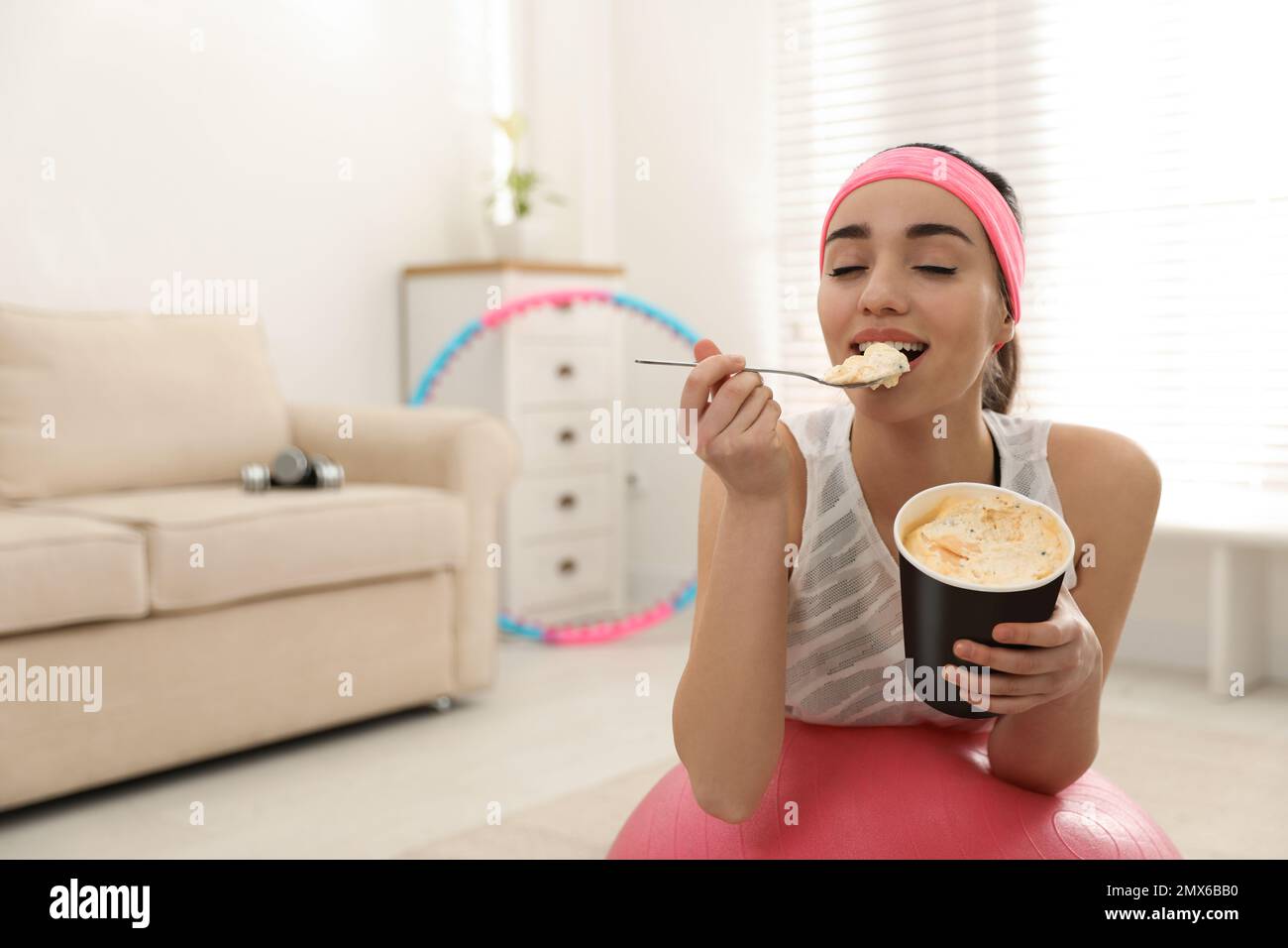 Lazy young woman eating ice cream at home. Space for text Stock Photo ...