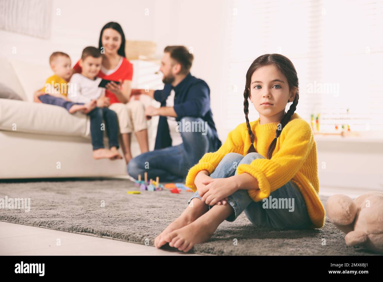 Unhappy little girl feeling jealous while parents spending time with ...