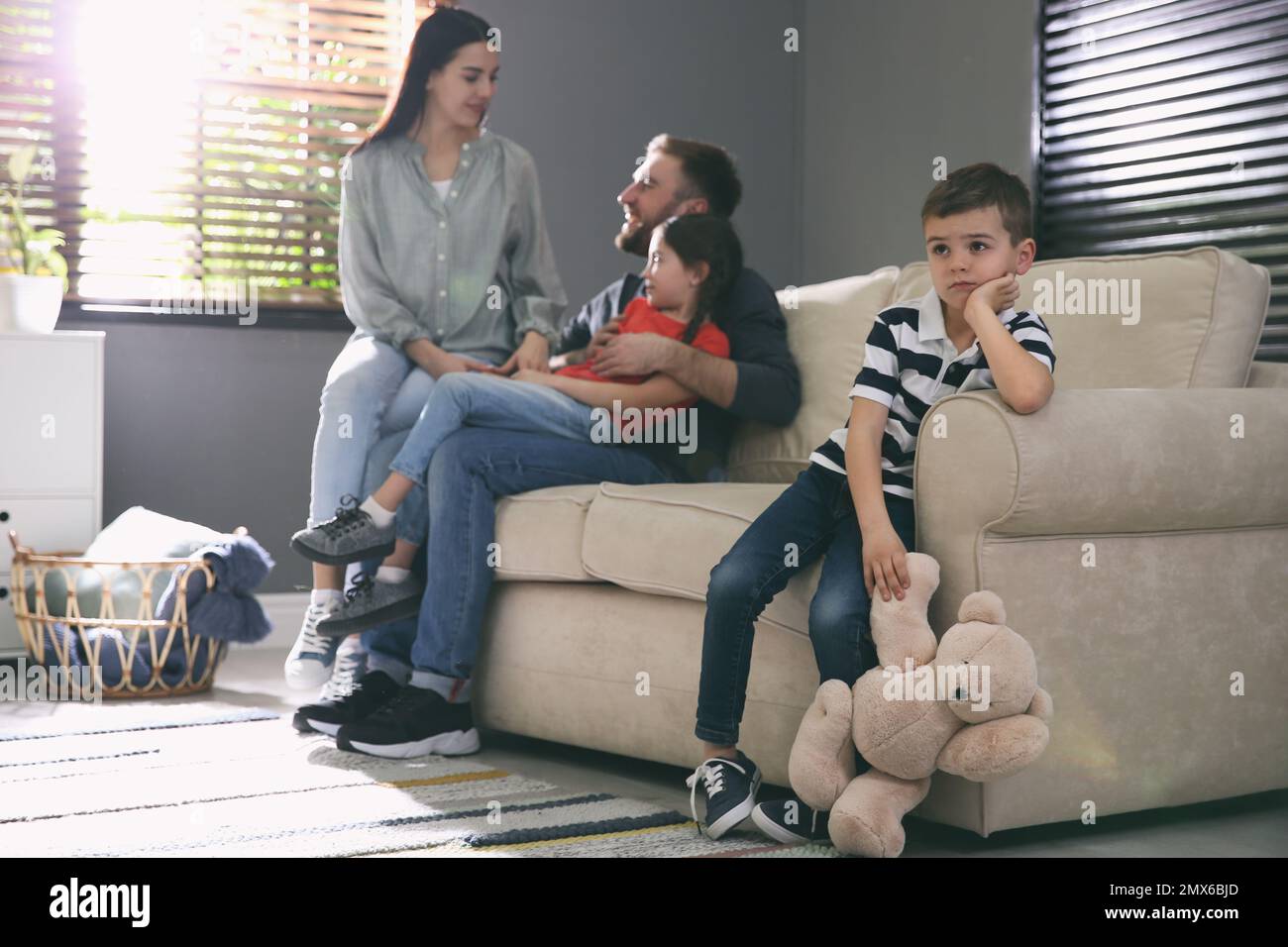 Unhappy little boy feeling jealous while parents spending time with his ...