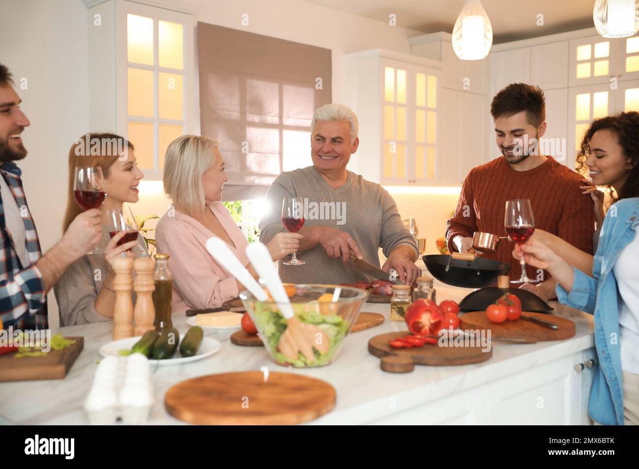 Happy people cooking food together in kitchen Stock Photo - Alamy