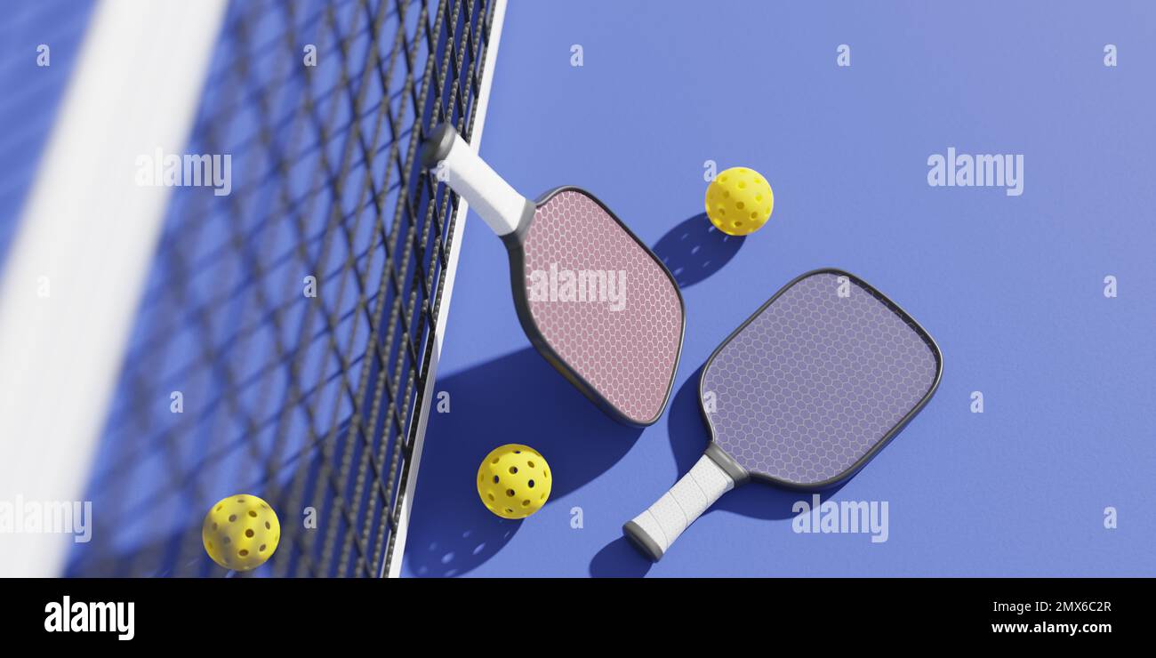 Rackets and balls for playing pickleball at the sports net on the court ...
