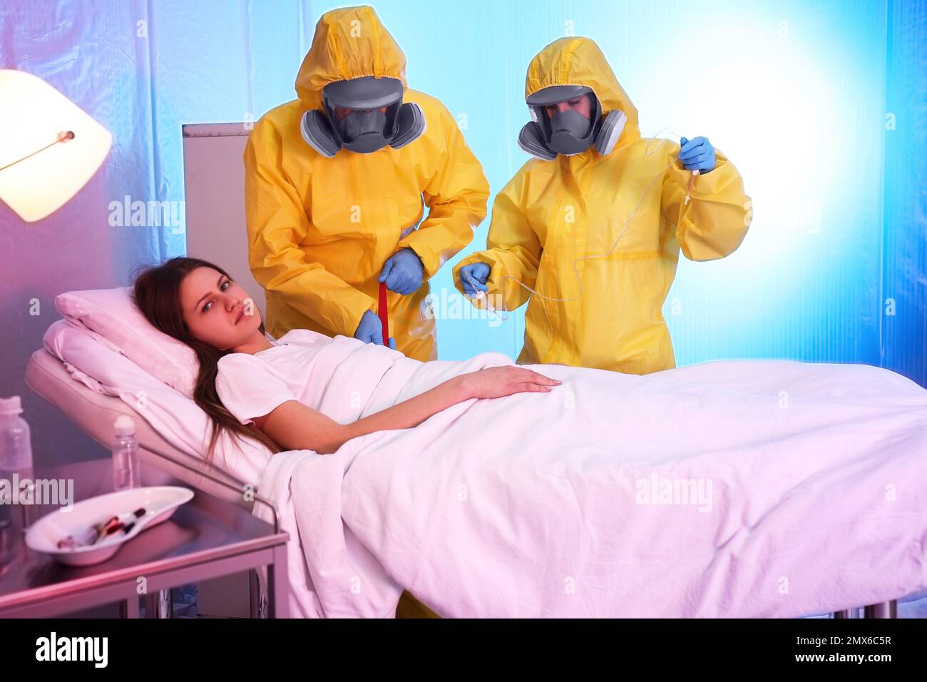 Paramedics wearing protective suits examining patient with virus in ...