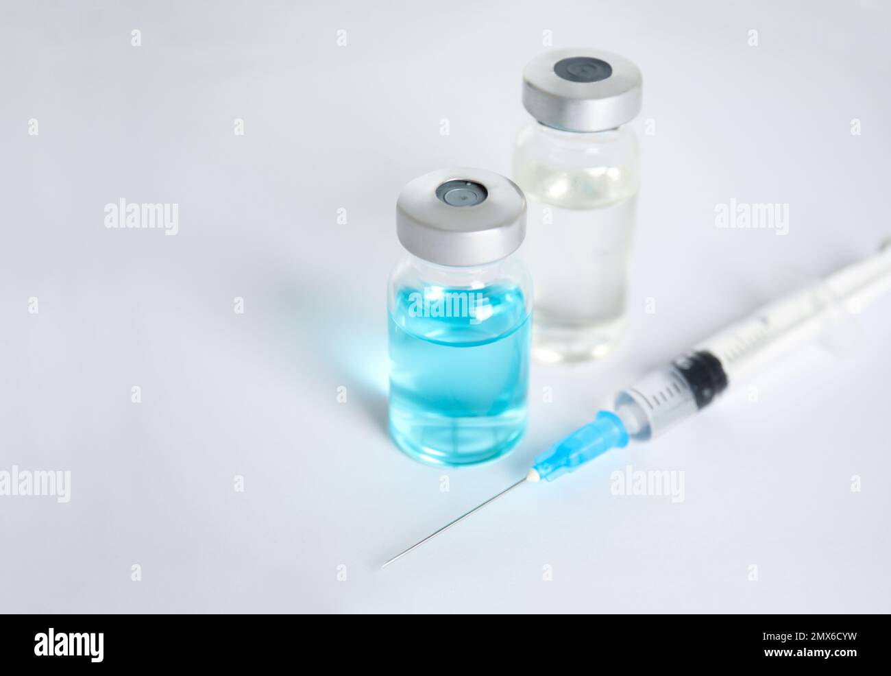 Vials and syringe on light background. Vaccination and immunization ...