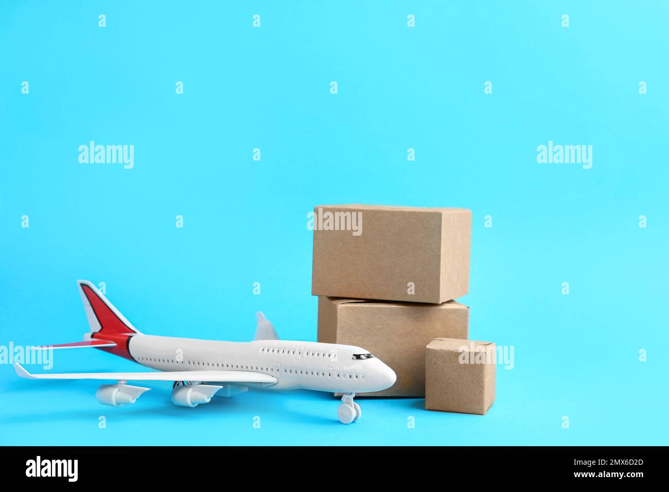 Airplane model and carton boxes on light blue background. Courier ...