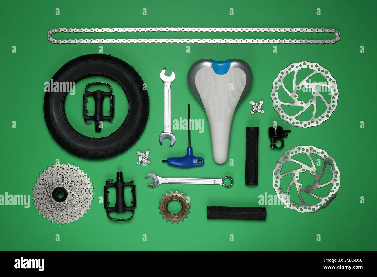 Set of different bicycle tools and parts on green background, flat lay ...