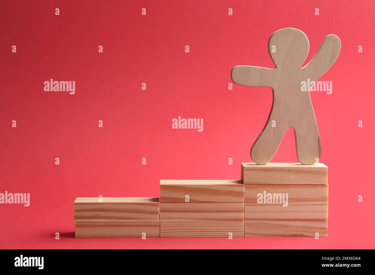 Wooden human figure on top of stairs against red background. Career ...