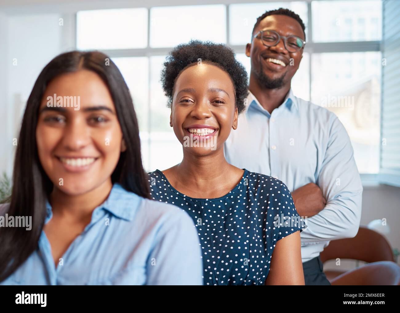 Trio of diverse business people lined up for portrait, focus on Black ...