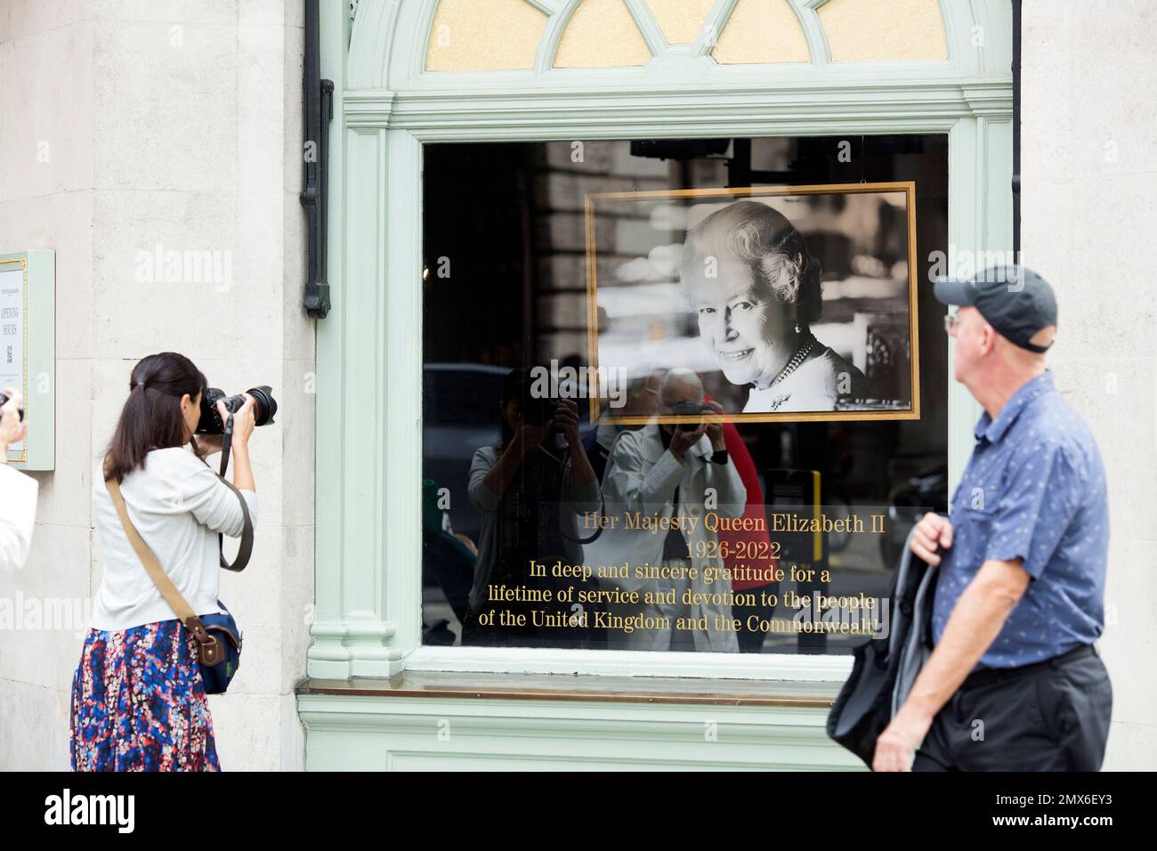 A portrait of Queen Elizabeth II is displayed in the shop window ...