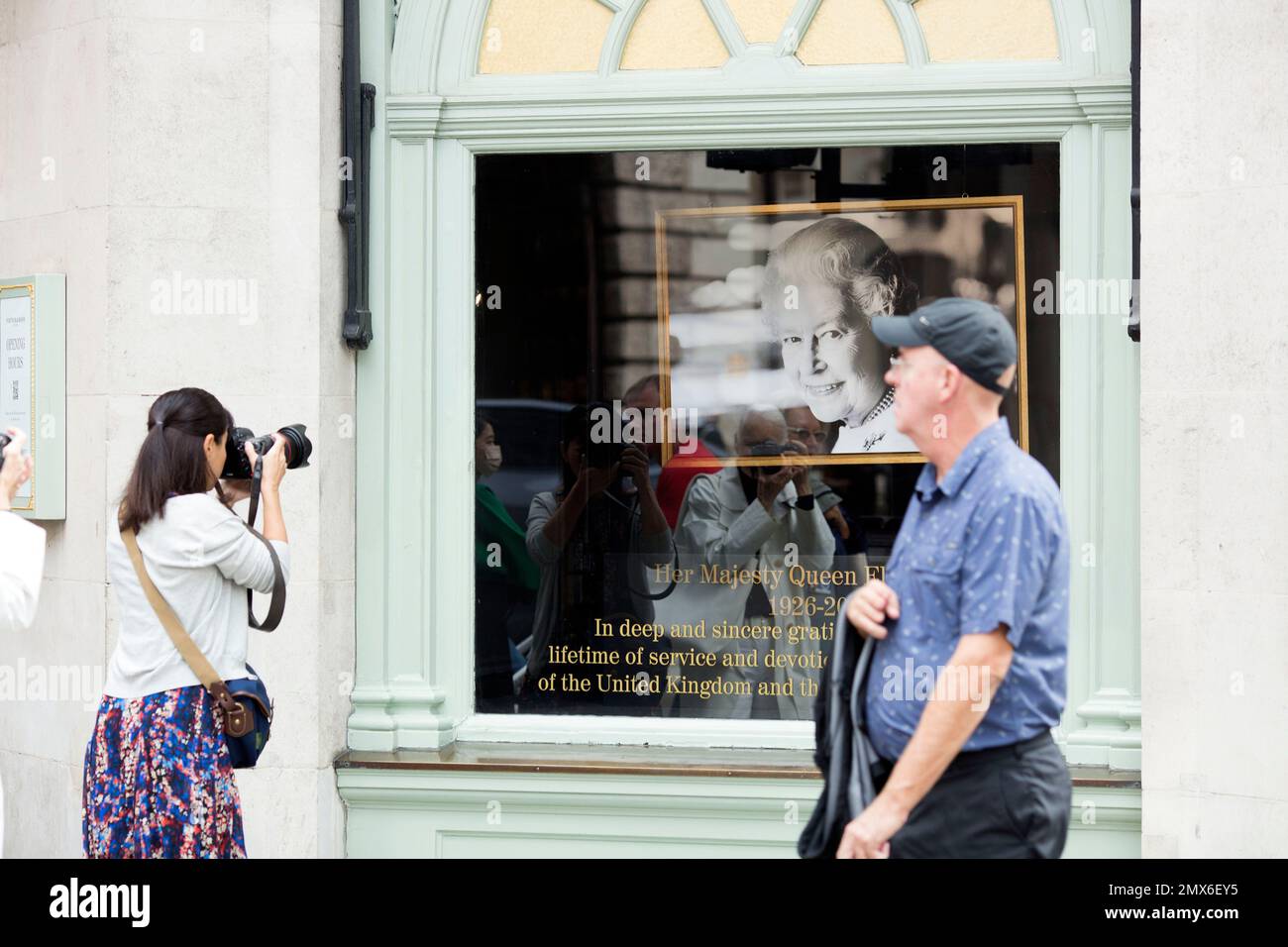 A portrait of Queen Elizabeth II is displayed in the shop window ...