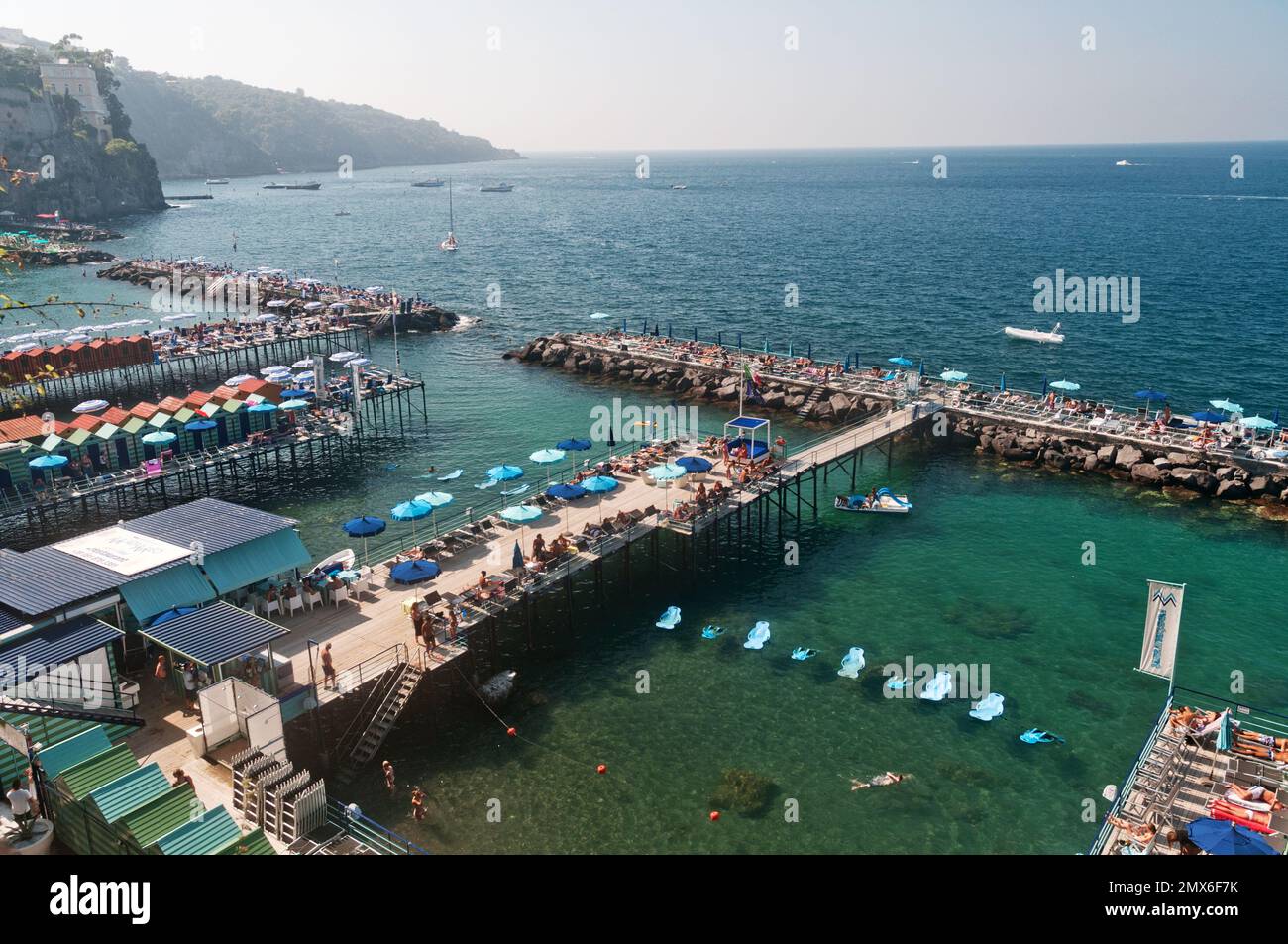 An aerial view of sunbathers and sunbeds with colourful parasols next ...