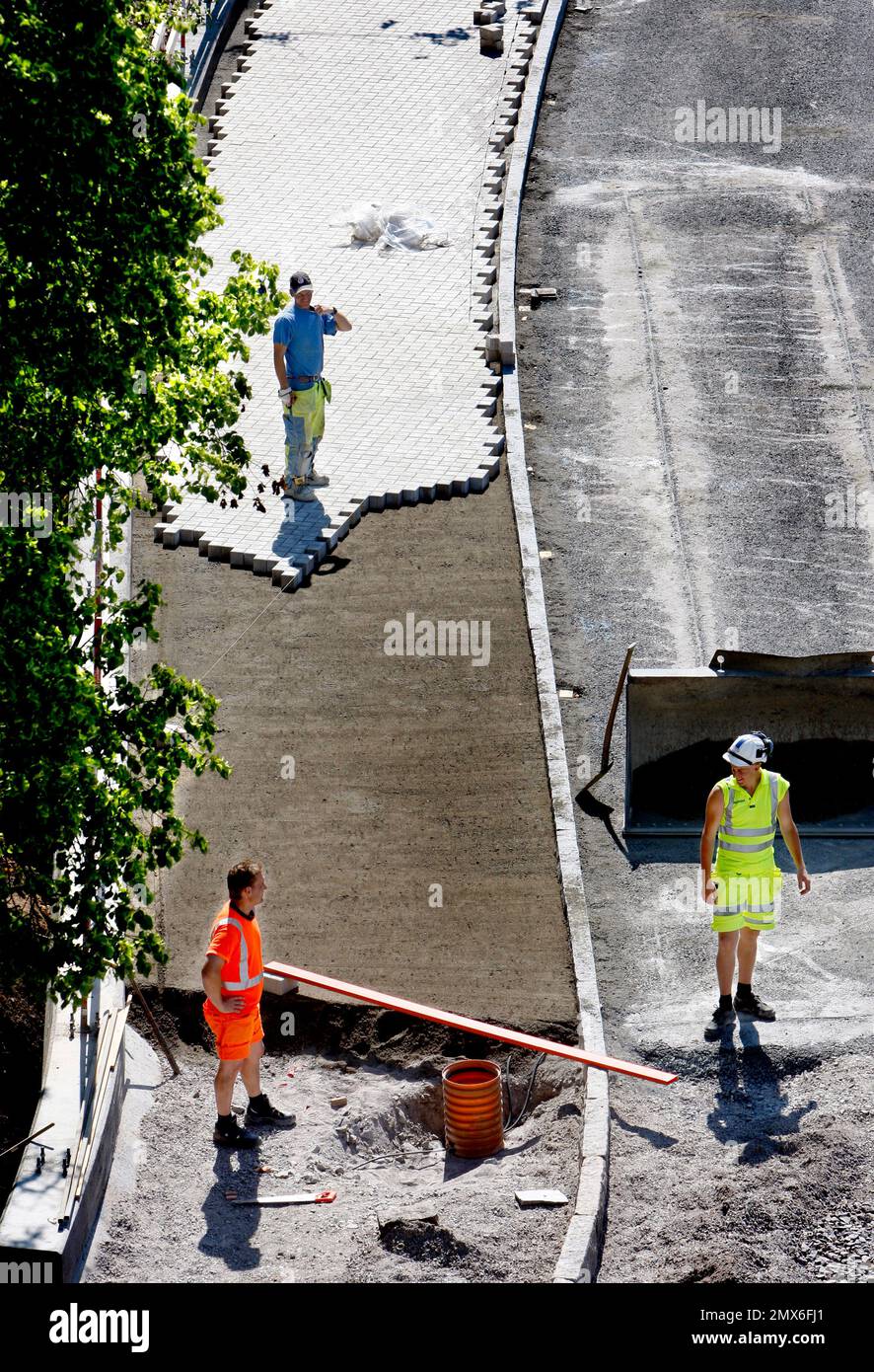 Paving on a pavement. Workers working on site Stock Photo - Alamy