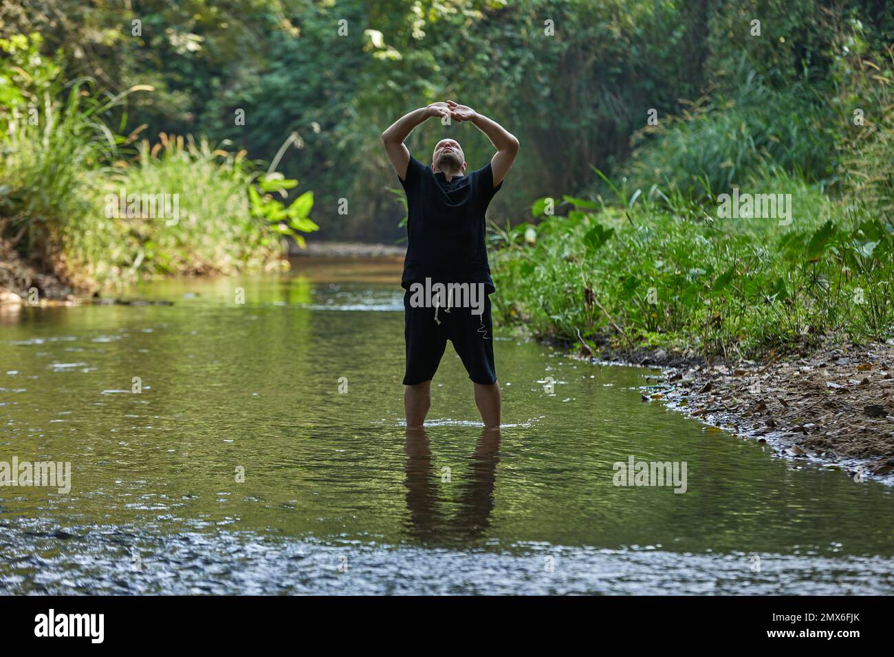 A man practices qigong and taijiquan while standing in a river in the ...