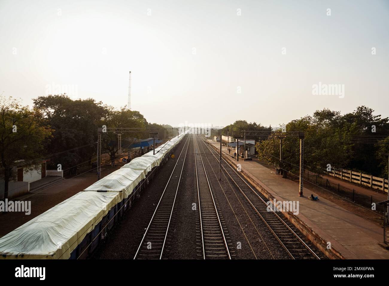 in india a loader train is standing in railway station at left side and ...