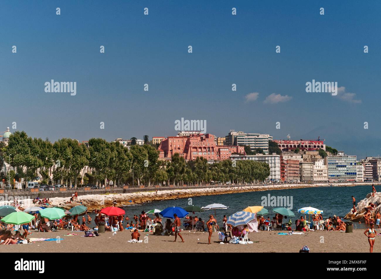 Young men and women sunbathing on Mappatella Beach in Naples, Italy ...