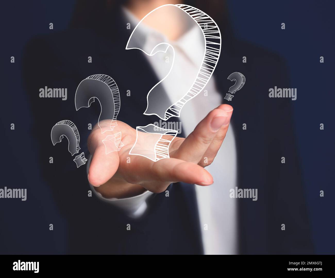 Businesswoman on blue background demonstrating drawing of question mark ...