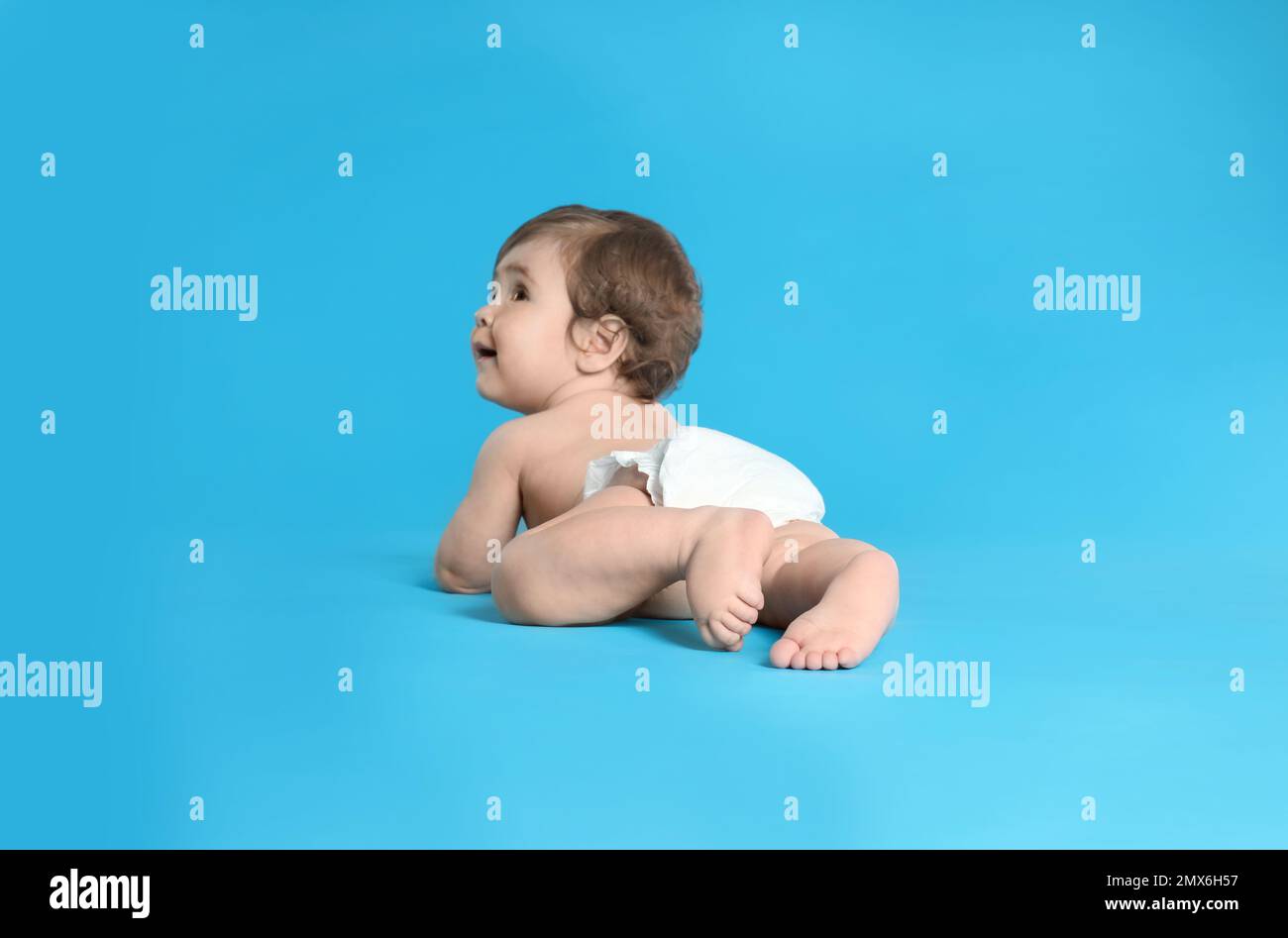 Cute little baby in diaper on light blue background Stock Photo - Alamy
