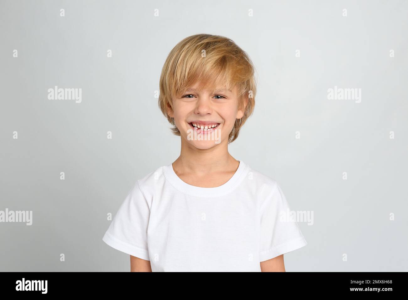 Happy little boy on light grey background Stock Photo - Alamy