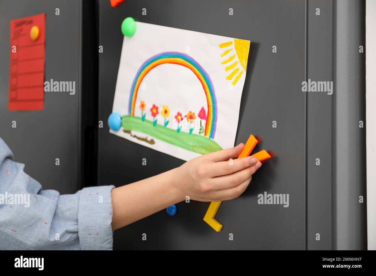Woman putting child's drawing on refrigerator door, closeup Stock Photo ...