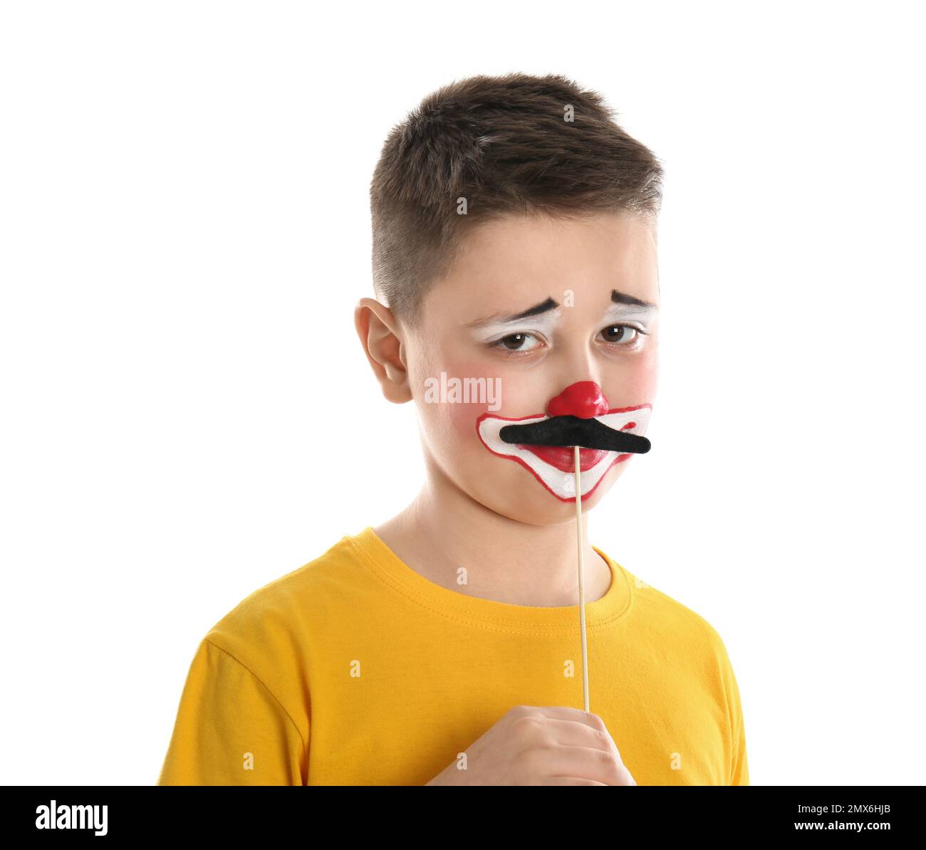 Preteen boy with clown makeup and fake mustache on white background ...