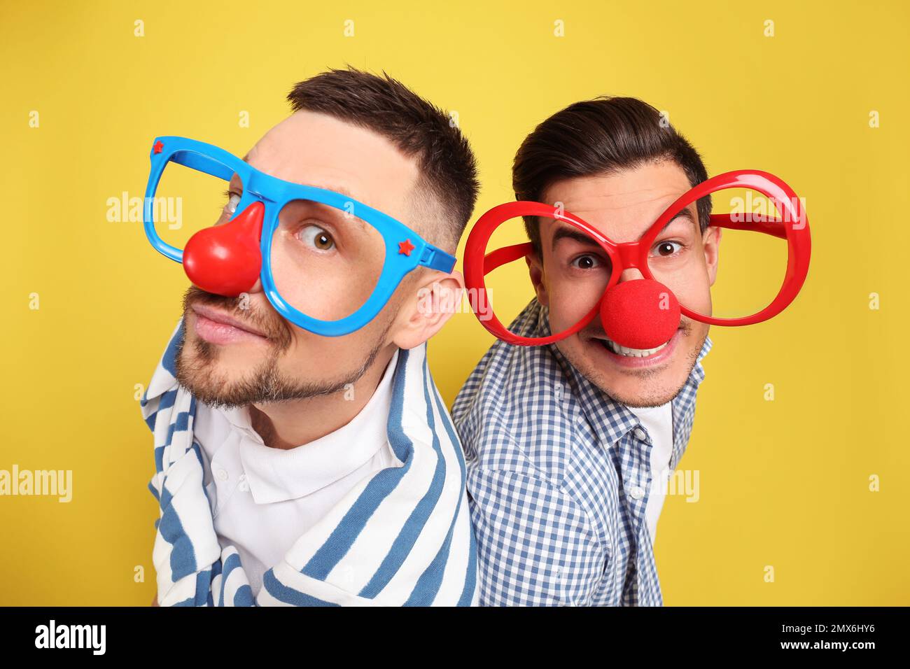 Men with funny accessories on yellow background. April fool's day Stock ...