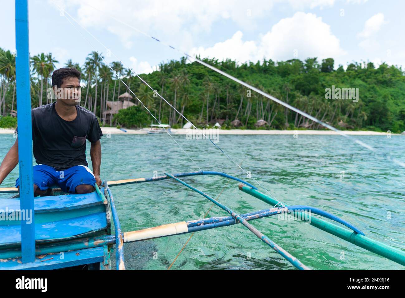 young asian fisherman sitting on his boat while watching at sea with ...