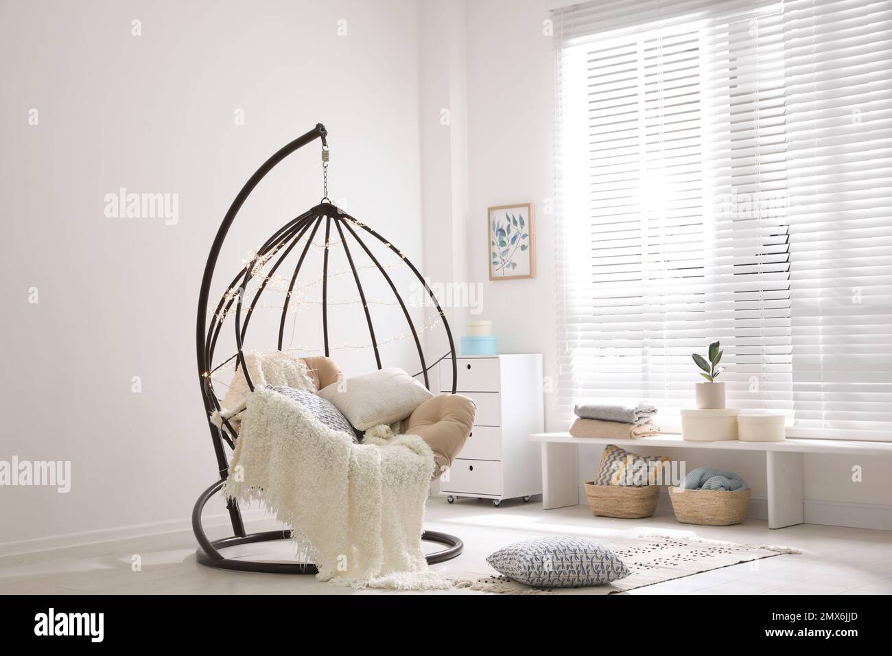 Cozy hanging chair with fairy lights in modern living room. Interior ...