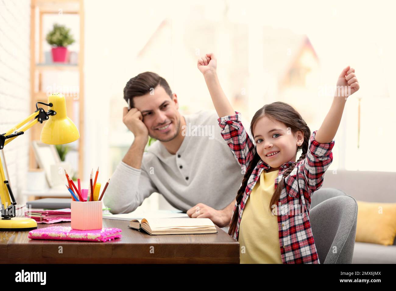 Father and daughter doing homework together at table indoors Stock Photo - Alamy