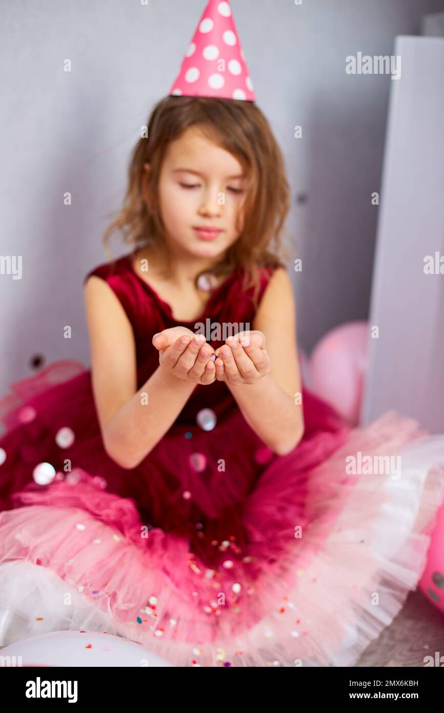 Beautiful Little Girl Blows Up Multicolored Confetti Having Fun At beautiful-little-girl-blows-up-multicolored-confetti-having-fun-at
