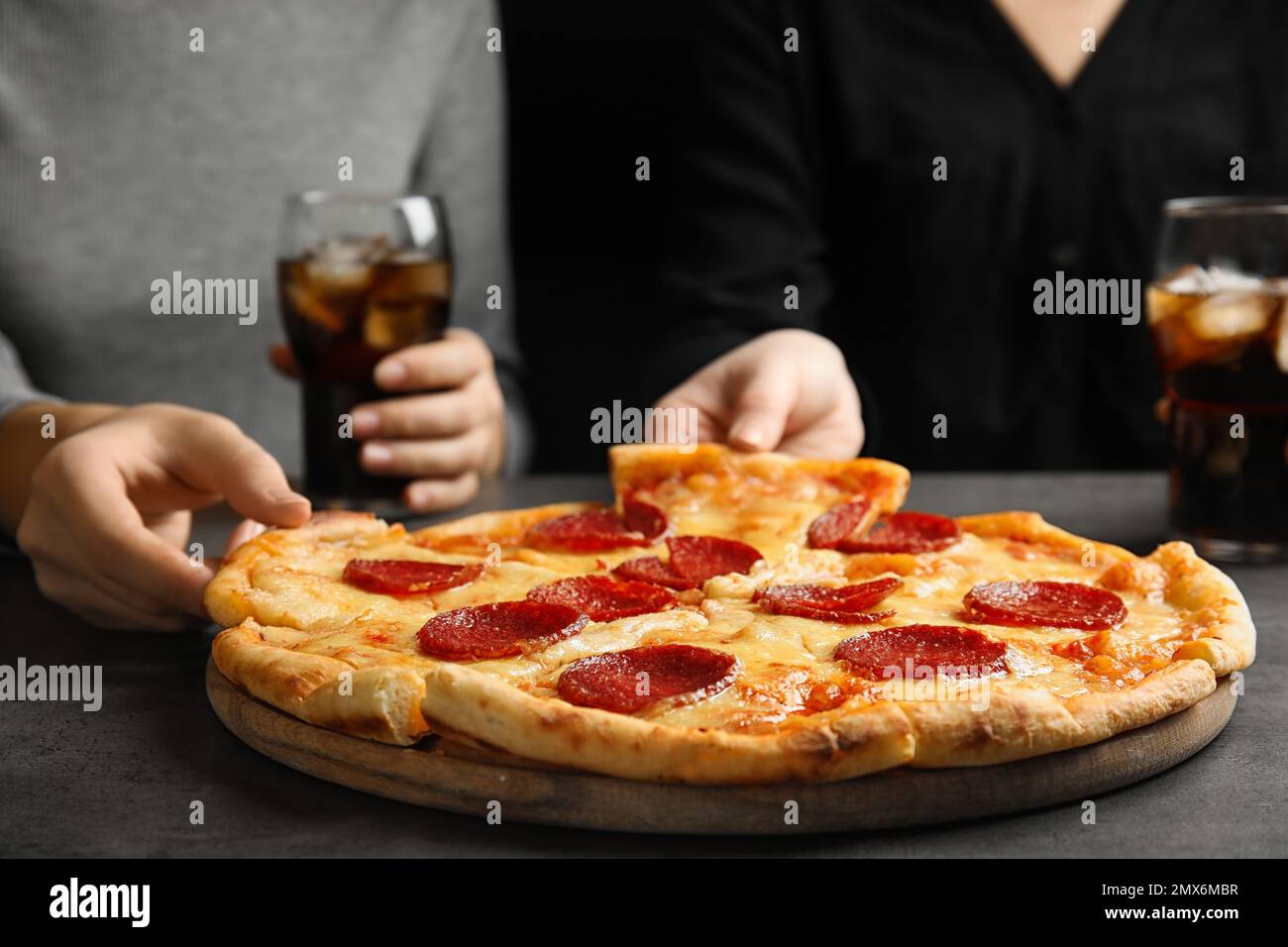 Women taking tasty pepperoni pizza at grey table, closeup Stock Photo ...