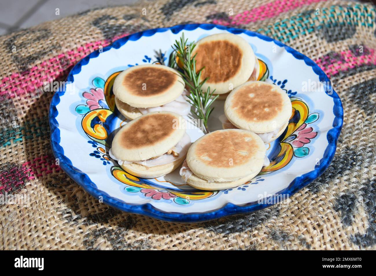 Italian finger food: polenta base with melted cheese, raw ham and ...