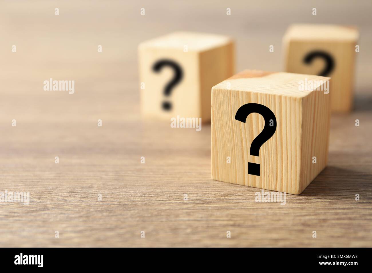 Cube with question mark on wooden background. Space for text Stock ...