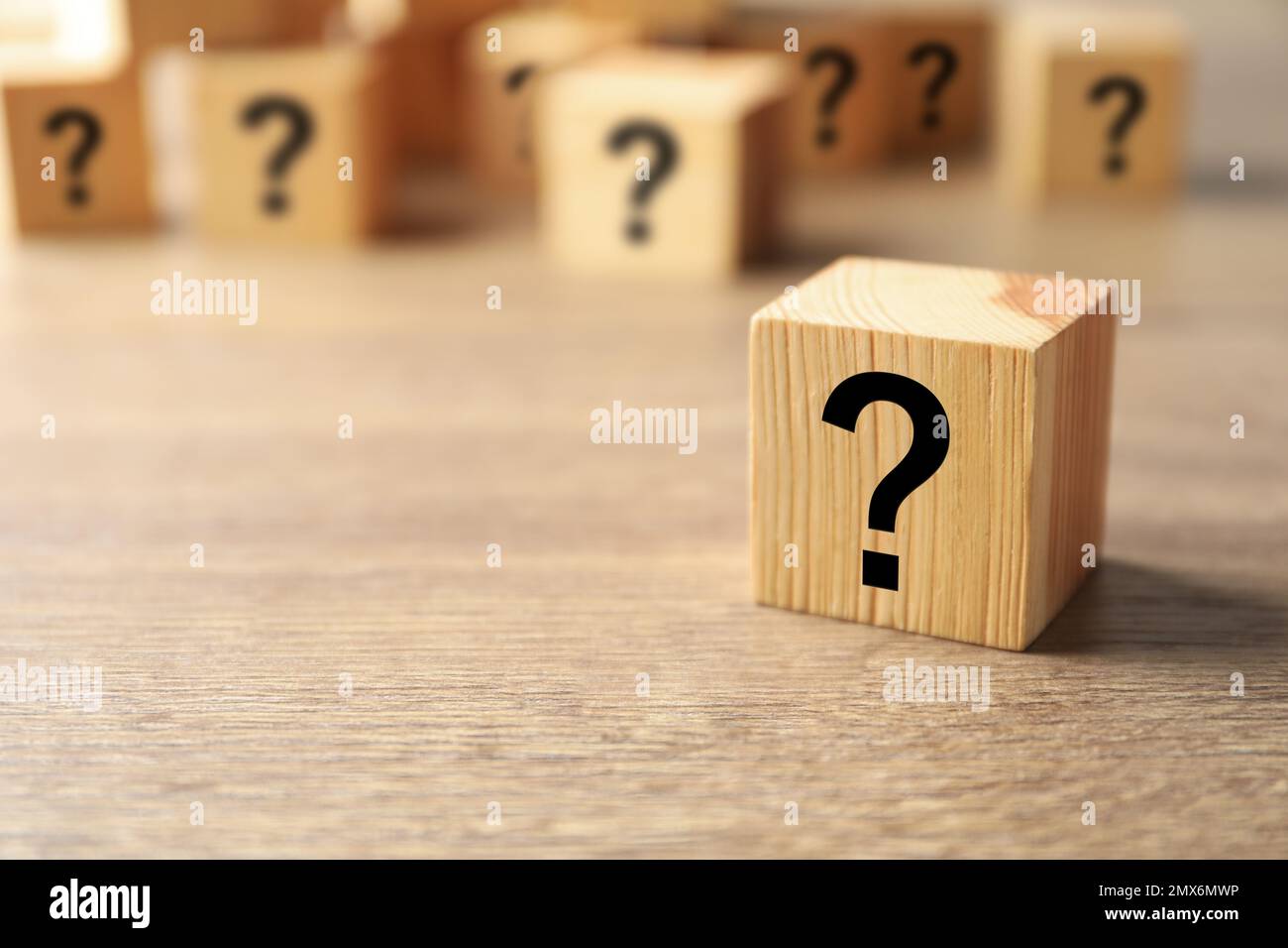 Cube with question mark on wooden background. Space for text Stock ...