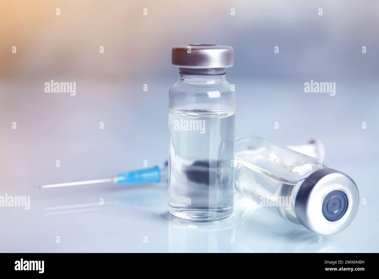 Vials and syringe on light table. Vaccination and immunization Stock ...