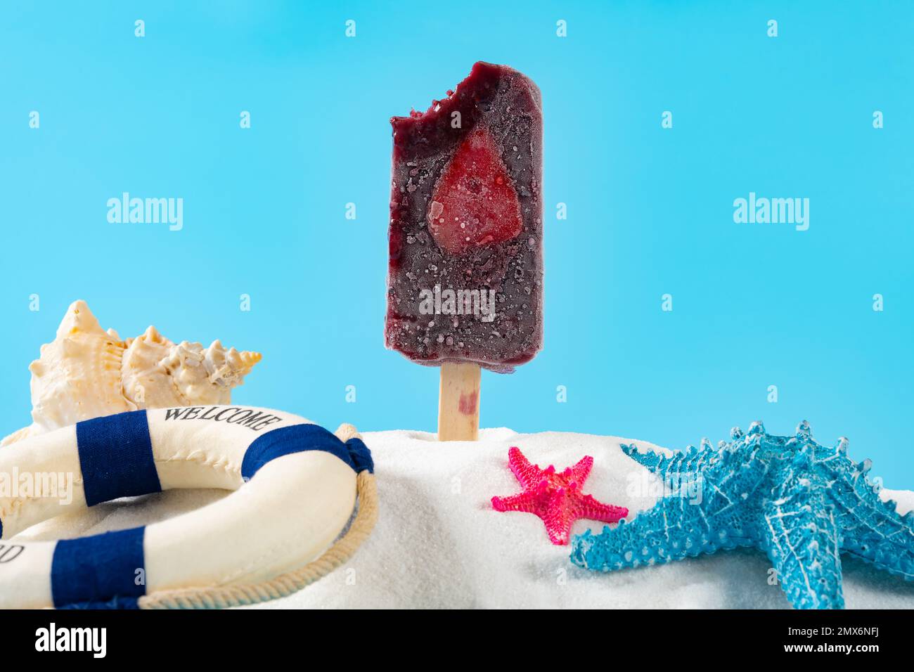 mulberry and blue berry flavor popsicle with a bite and starfishes on ...