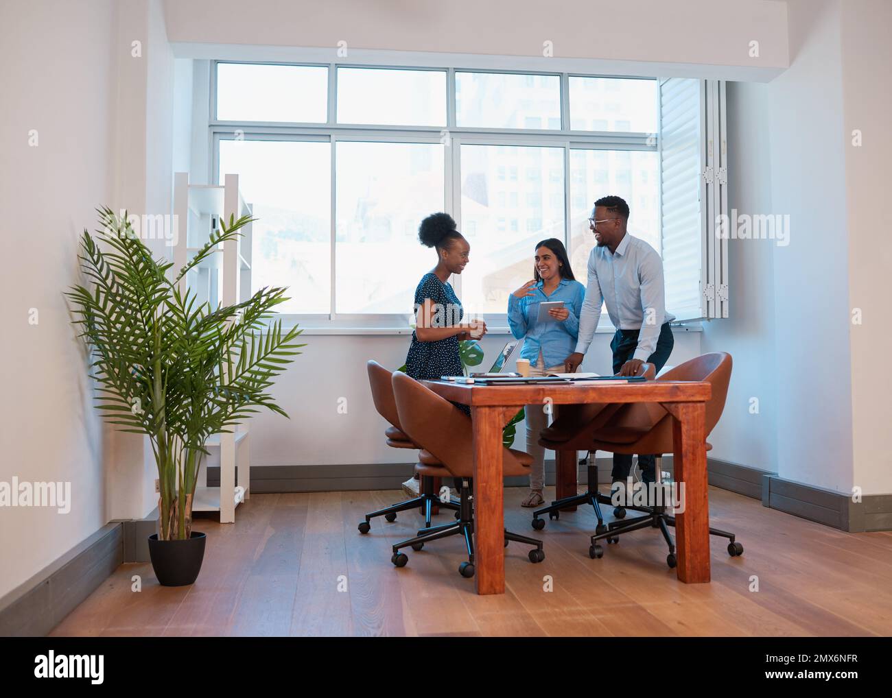 Wide shot of office scene, boardroom meeting three people standing ...