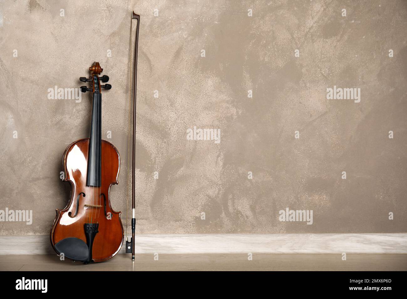 Classic violin and bow near beige wall. Space for text Stock Photo - Alamy