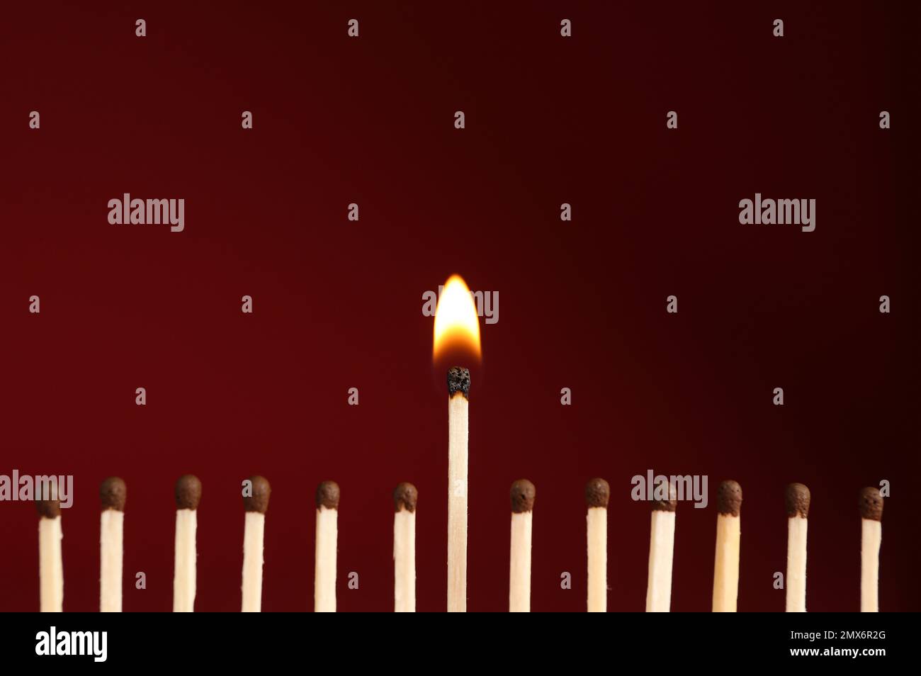 Burning match among unlit ones on red background, closeup Stock Photo ...