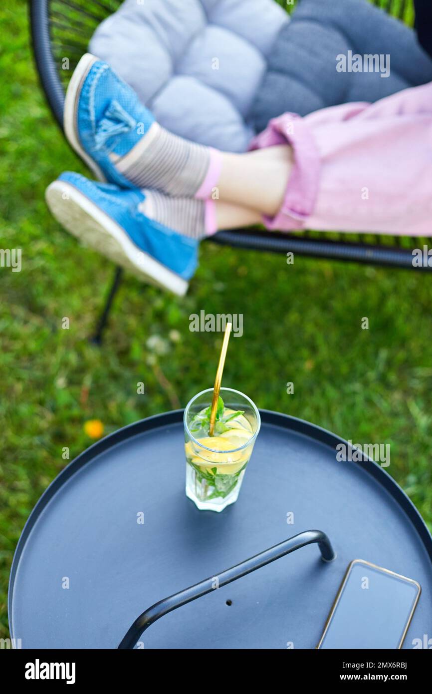 Summer citrus lemonade with reusable metal straws, Woman leg home in ...