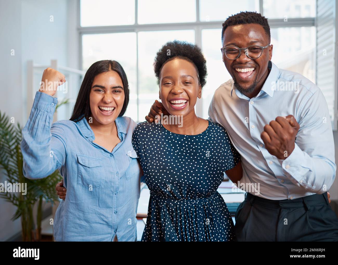 Three business people celebrate successful achievement in office cheer ...