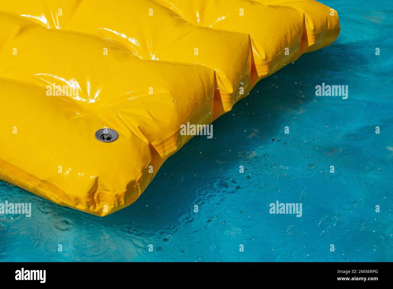 The yellow inflatable mattress on the outdoor swimming pool. Air pool ...