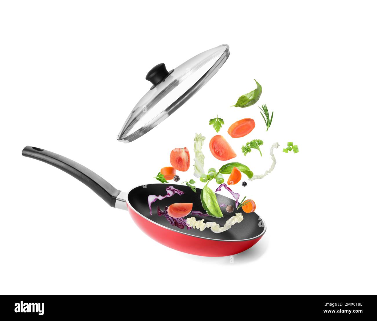 Different vegetables falling into frying pan on white background ...